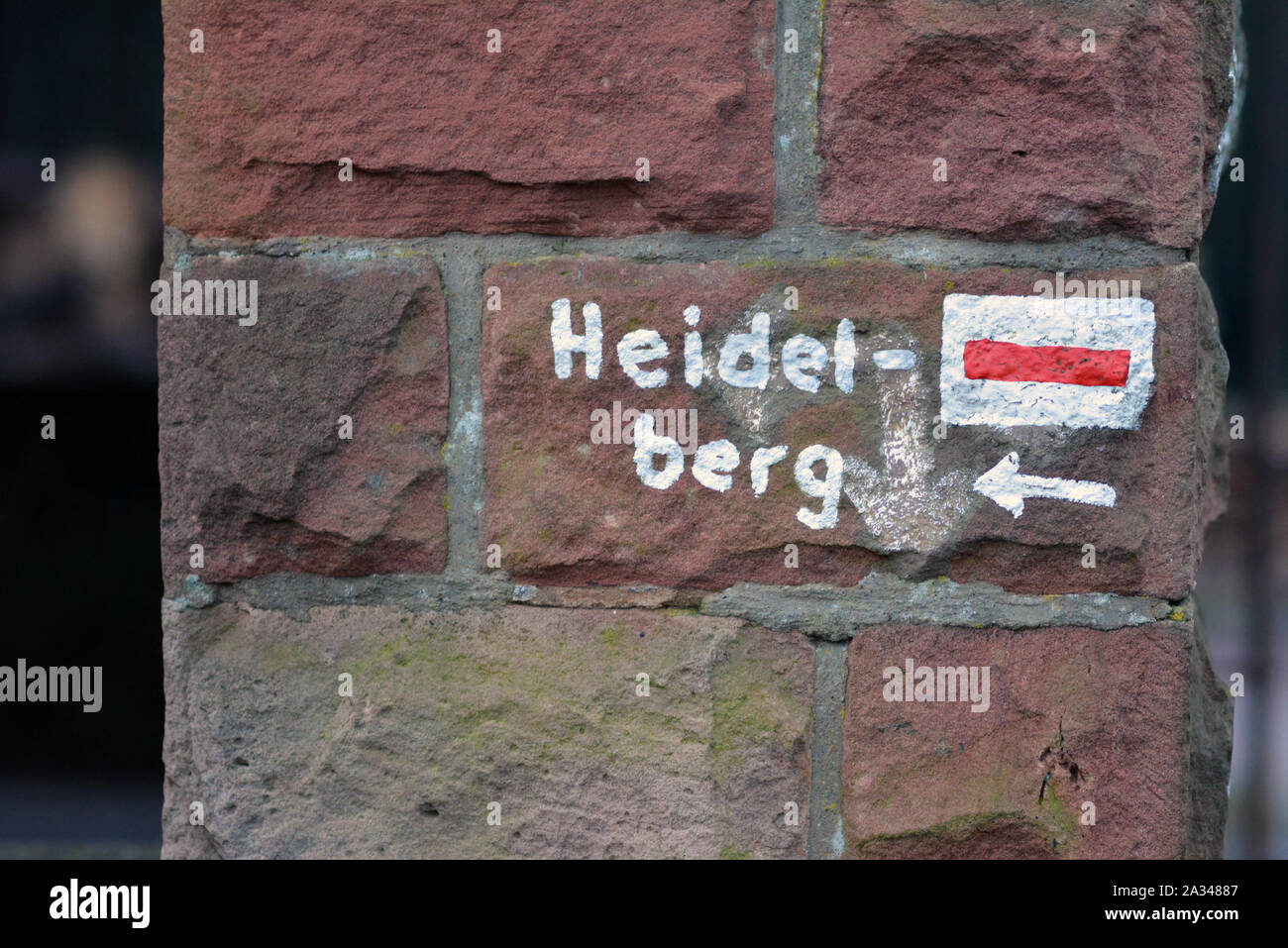 Handwritten signpost with white paint on an old stone brick wall ...