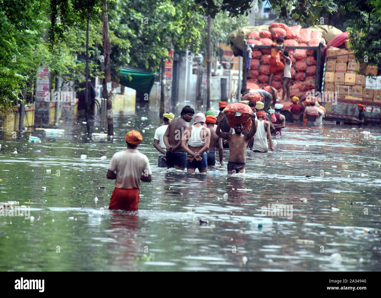 Patna, India. 4th Oct, 2019. People carry potatoes for flood victims in ...