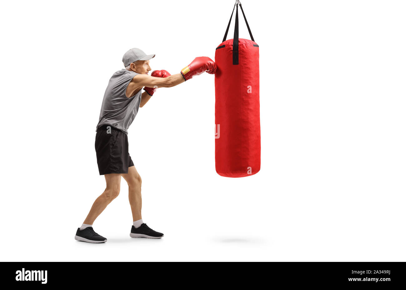 Full length profile shot of an elderly man with boxing gloves punching ...