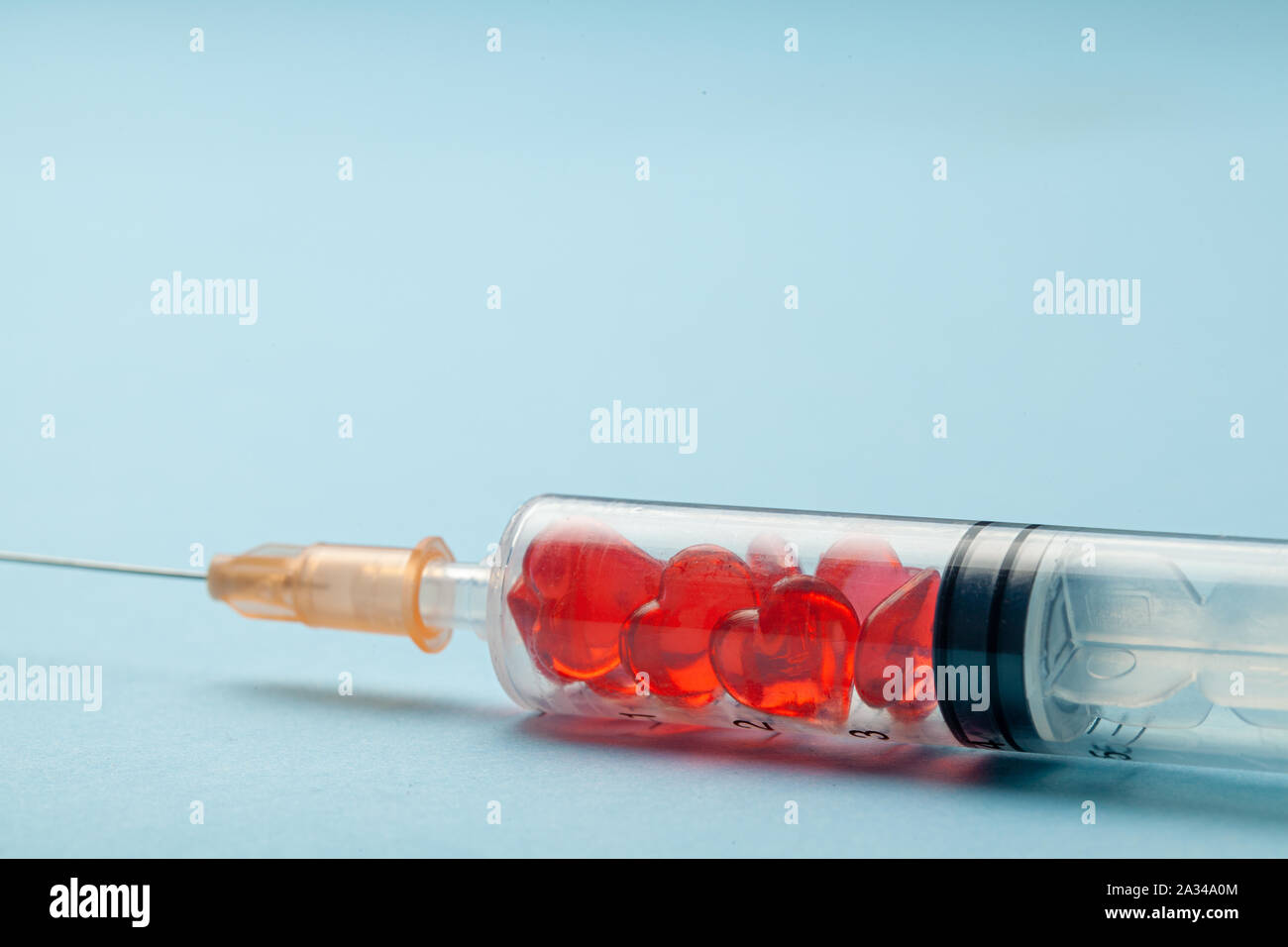 Syringe with red hearts inside. Concept for heart treatment or love ...