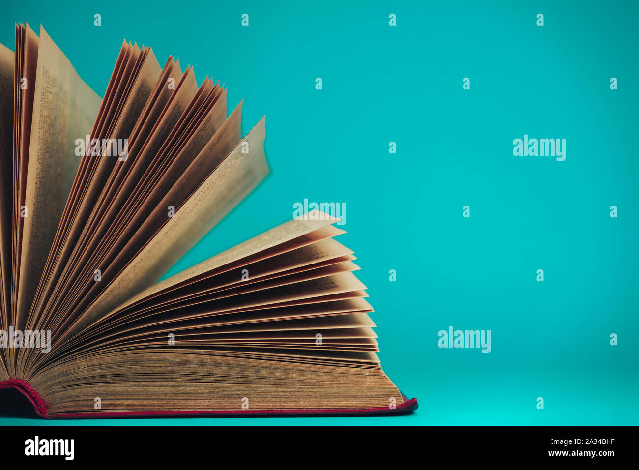 Beautiful open red book on a aquamarine background Stock Photo - Alamy