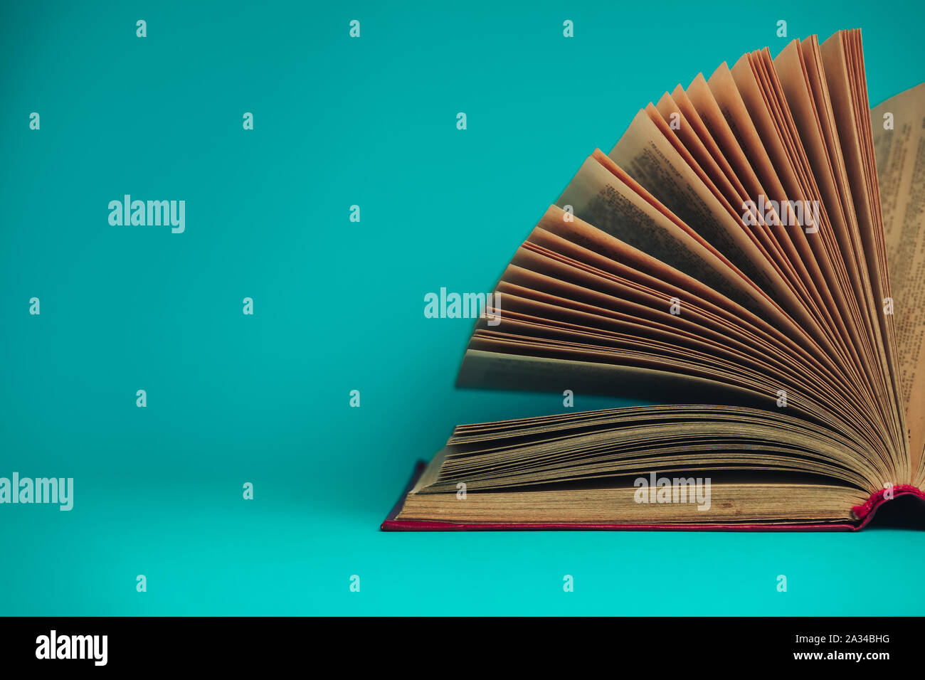 Beautiful open red book on a aquamarine background Stock Photo - Alamy
