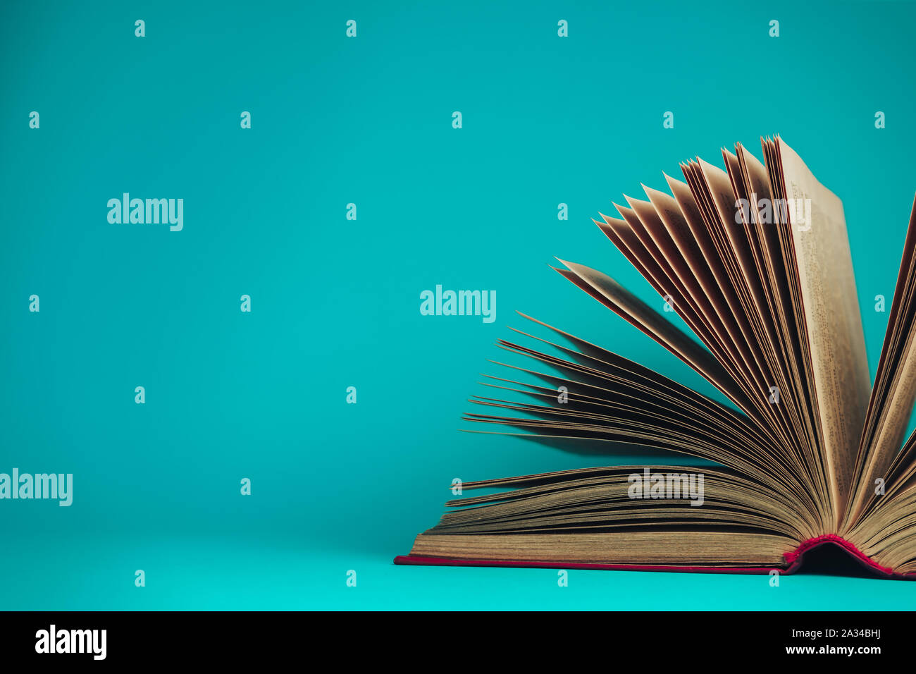 Beautiful open red book on a aquamarine background Stock Photo - Alamy