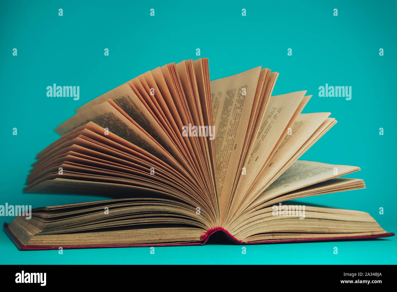 Beautiful open red book on a aquamarine background Stock Photo - Alamy