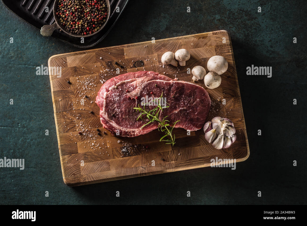 Rib Eye steak salt pepper spices garlic and mushroom. Raw beef meat on ...