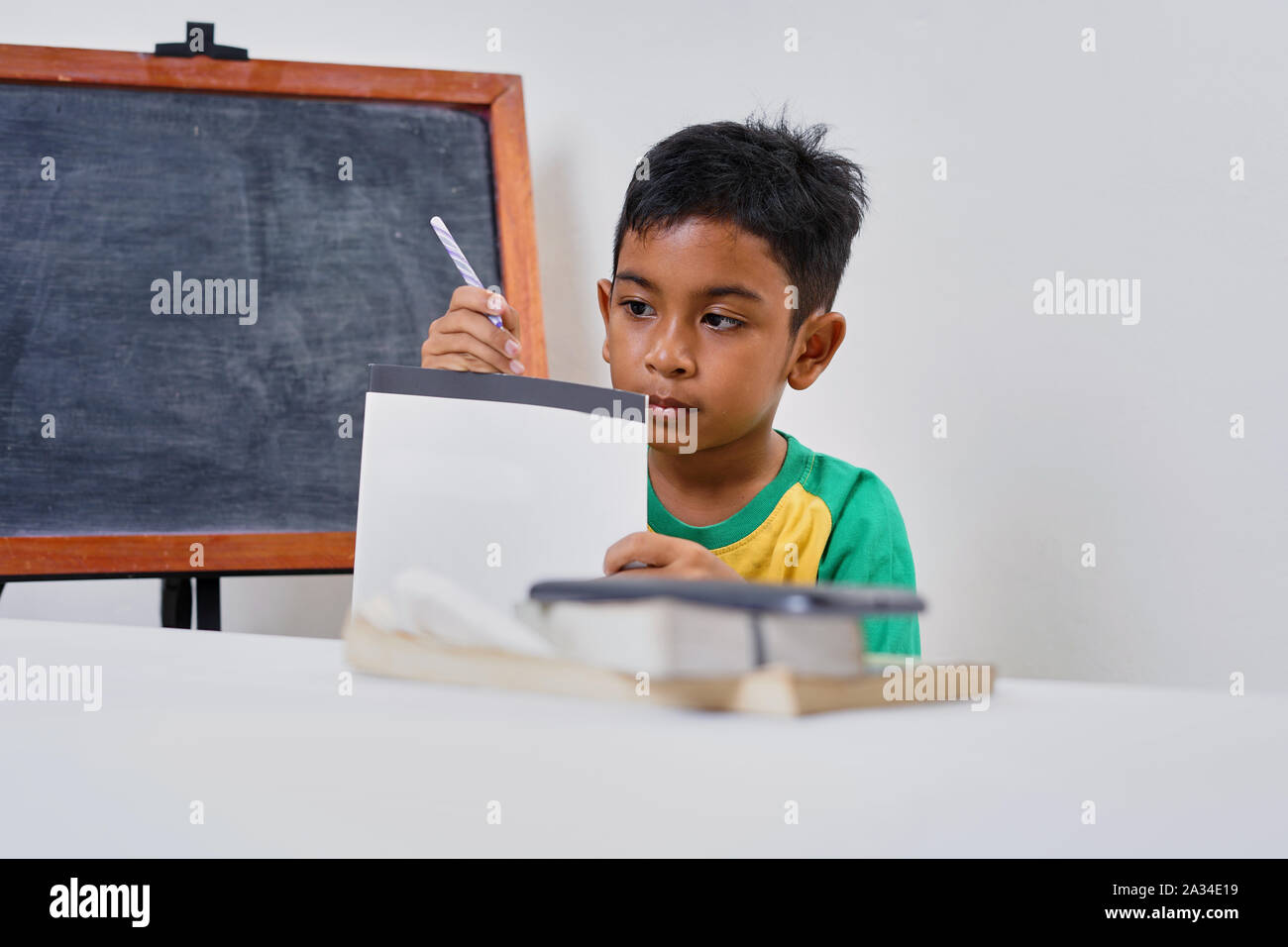 Elementary student boy taking a test in classroom Stock Photo - Alamy