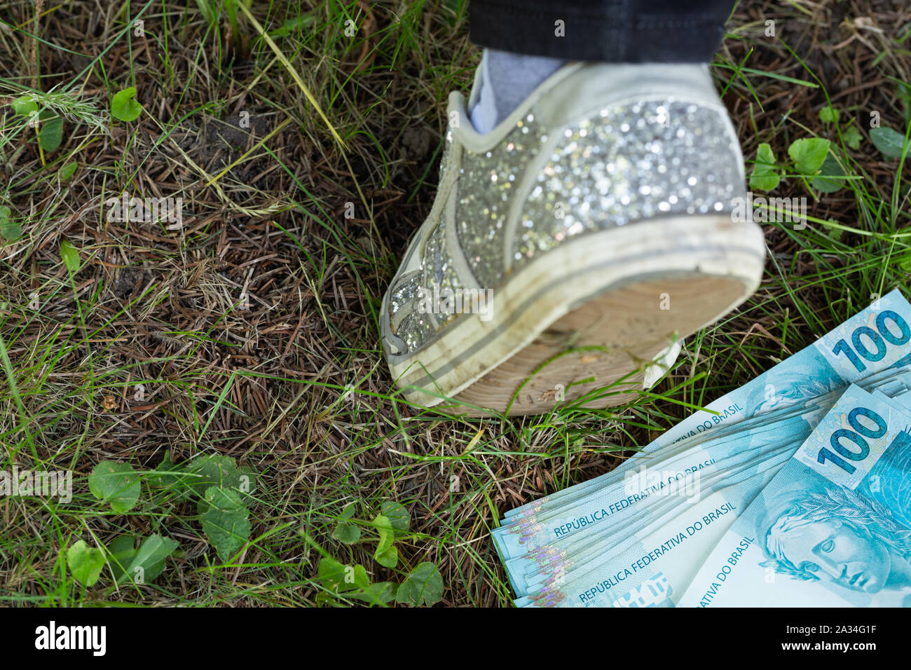 Brazilian money, denominations of 100 reais lying on the ground under ...