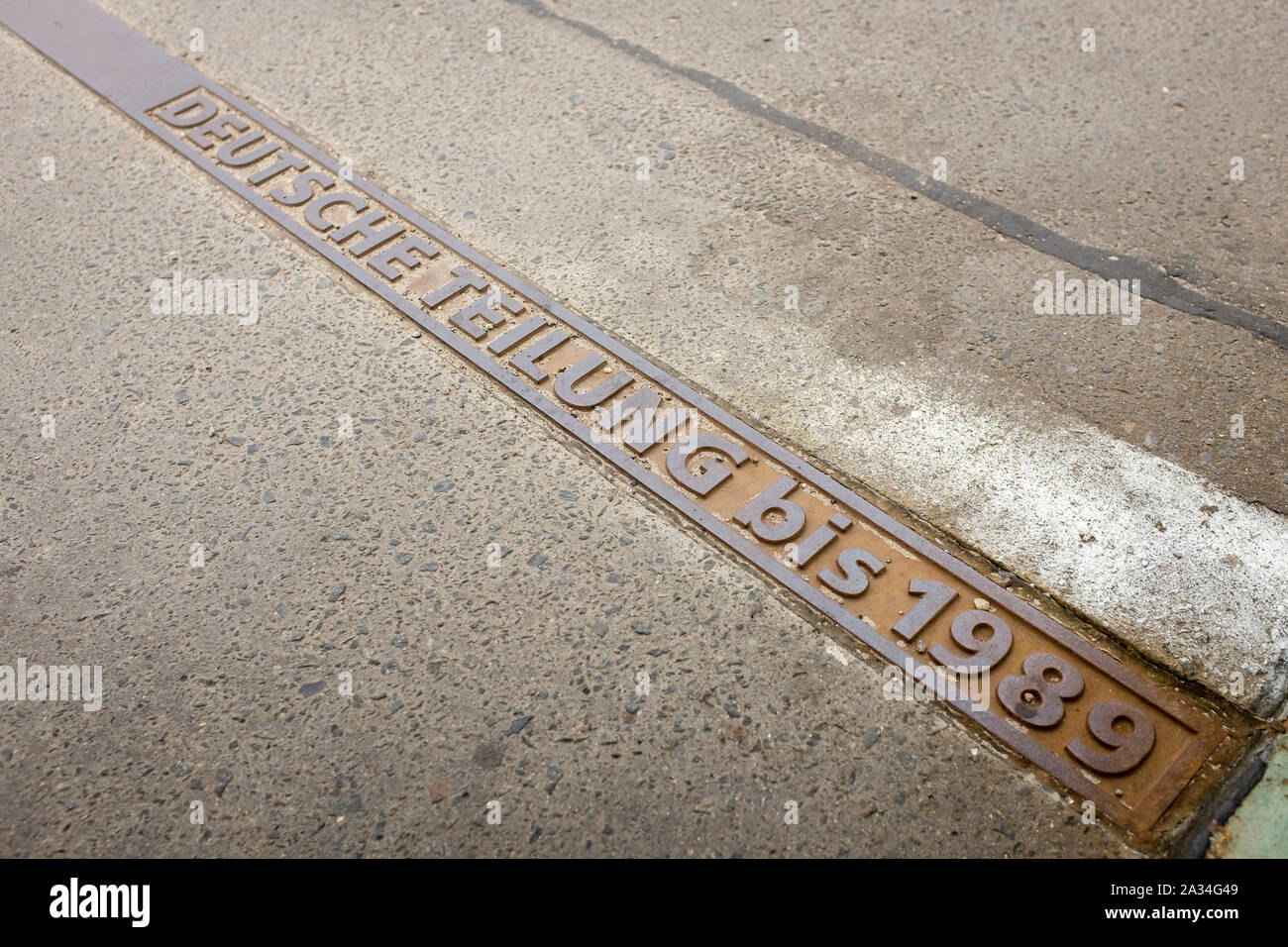 Metal sign in the ground noting the former East - West border (until ...