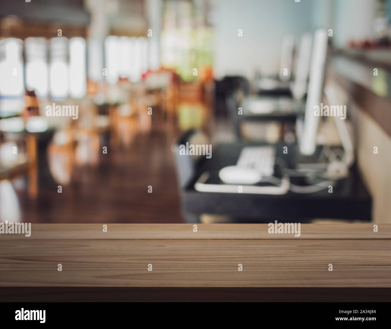 Emty wooden table with blurred public computer in business center ...