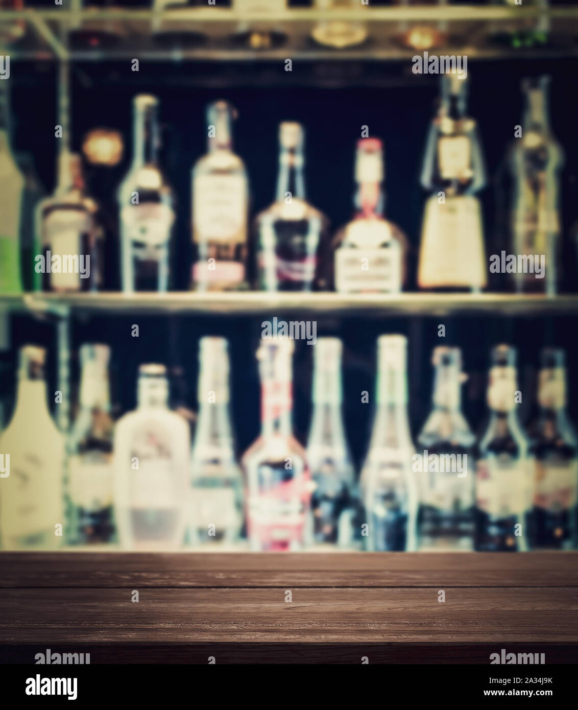 Empty wooden table with blurred alcoholic drinks are on the shelf ...