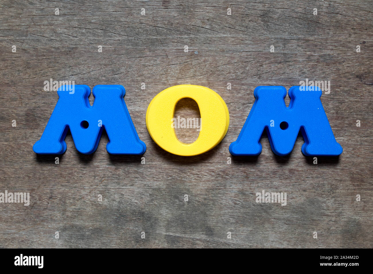 Color alphabet in word mom on wood background Stock Photo - Alamy