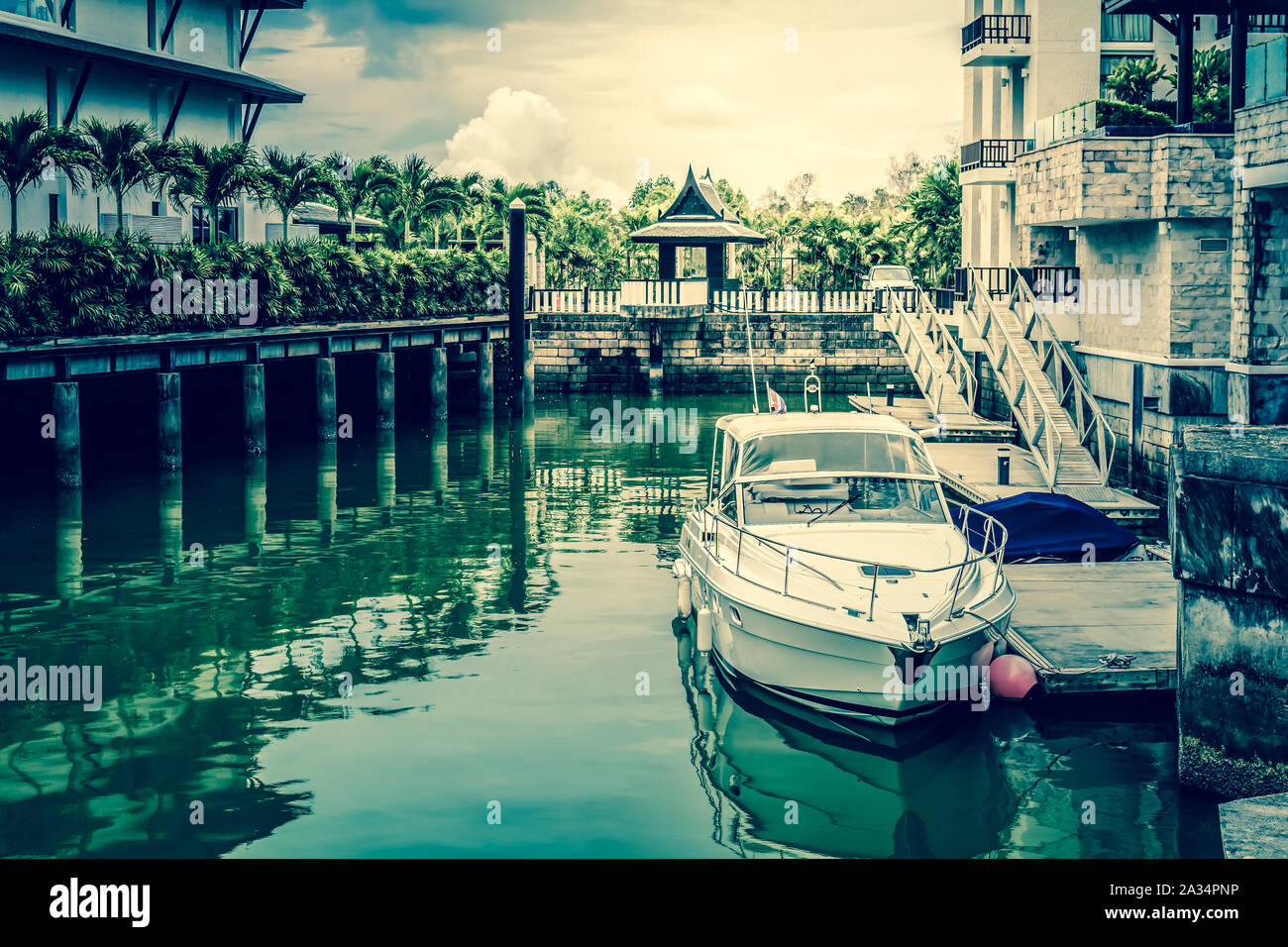 White speed boat at the pier with contemporary building under sunlight ...