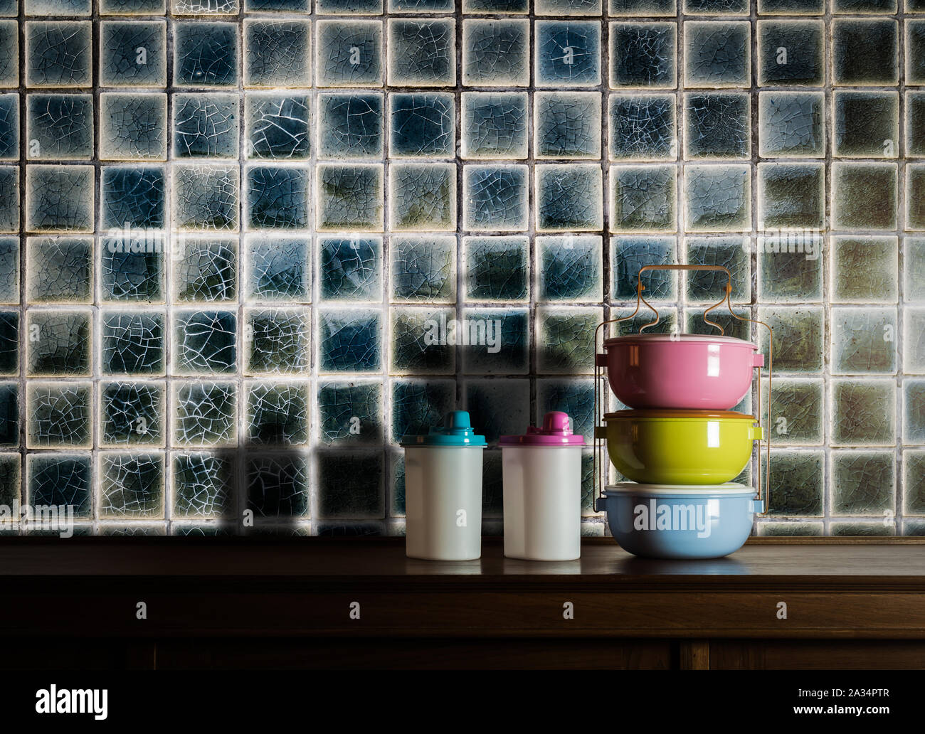 Colorful tiffin carrier and plastic bottles on wooden cupboard with ...