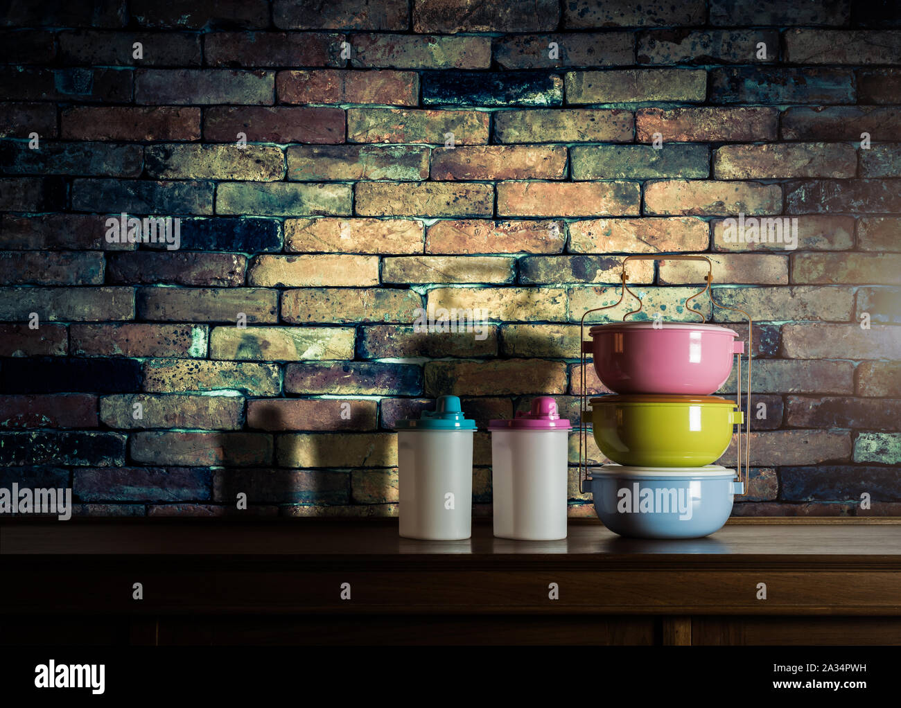 Colorful tiffin carrier and plastic bottles on wooden cupboard with ...