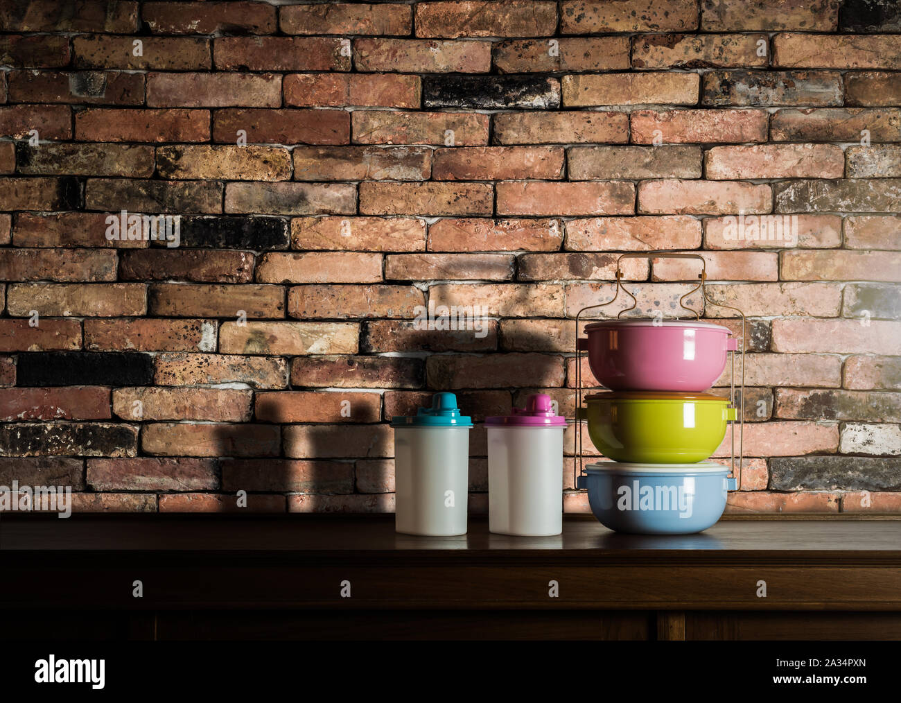 Colorful tiffin carrier and plastic bottles on wooden cupboard with ...