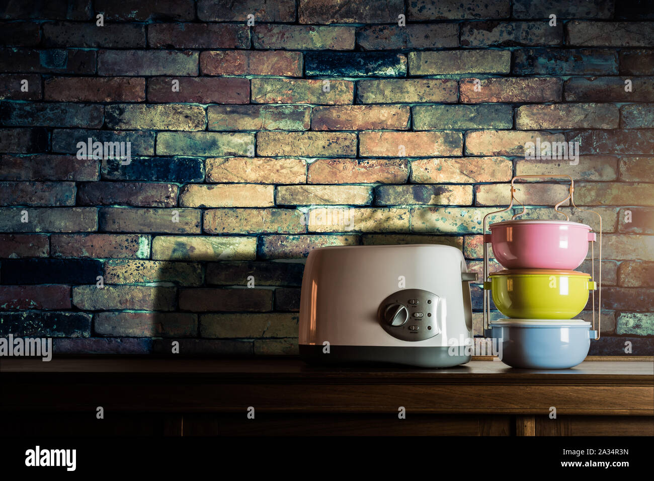 Colorful tiffin carrier and toaster on wooden cupboard with vintage ...