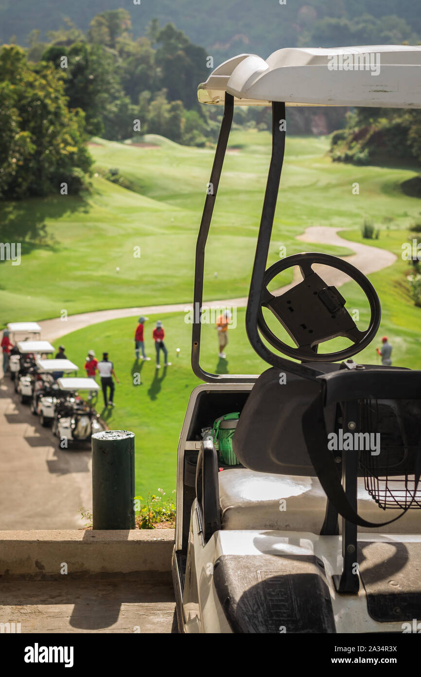 Golf club cars at golf field with golfers are on started point Stock ...
