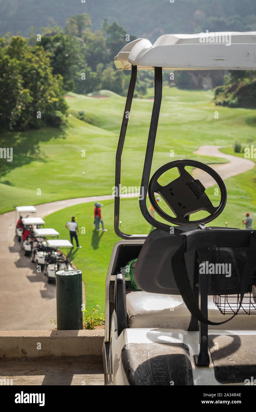 Golf club cars at golf field with golfers are on started point Stock ...