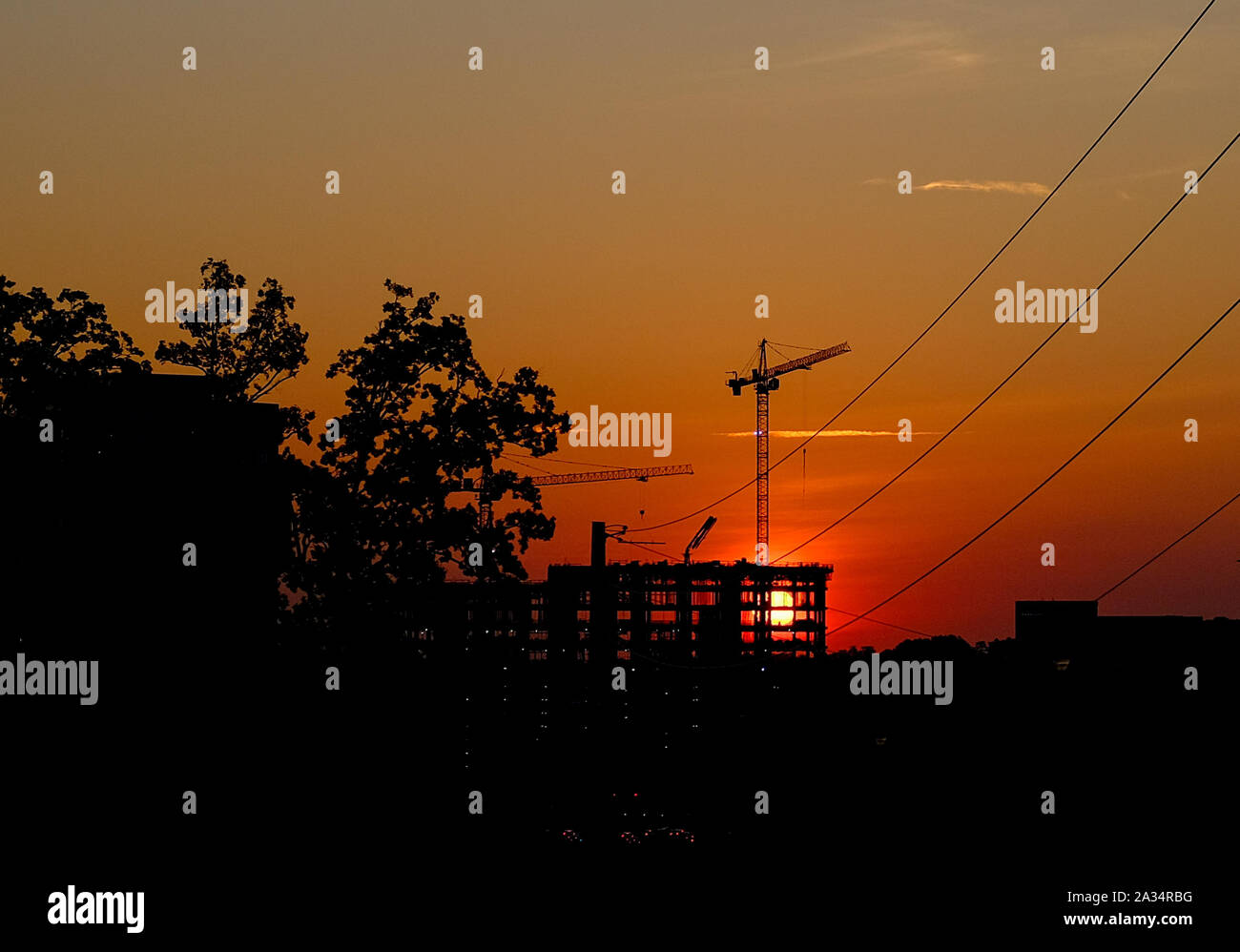 Sunrise shining through a new building at a construction site with ...