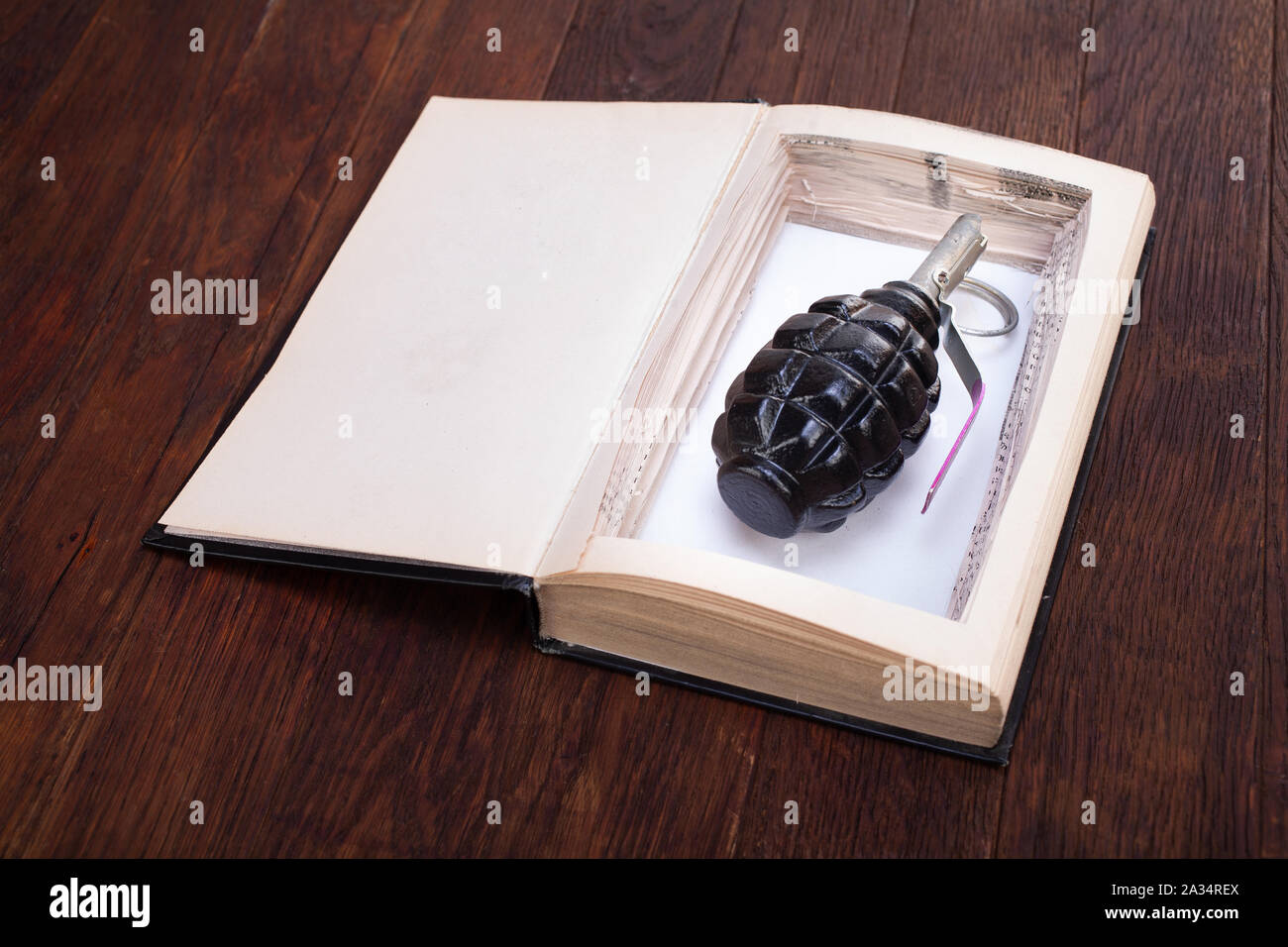 black hand grenade hidden in a book Stock Photo - Alamy