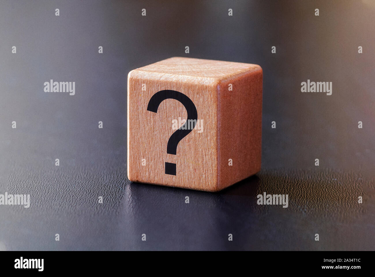 Question mark on a small wooden block over a texture blue background ...