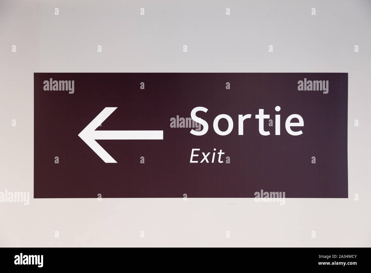 Rectangular dark blue plate with white letters and an arrow pointing to ...