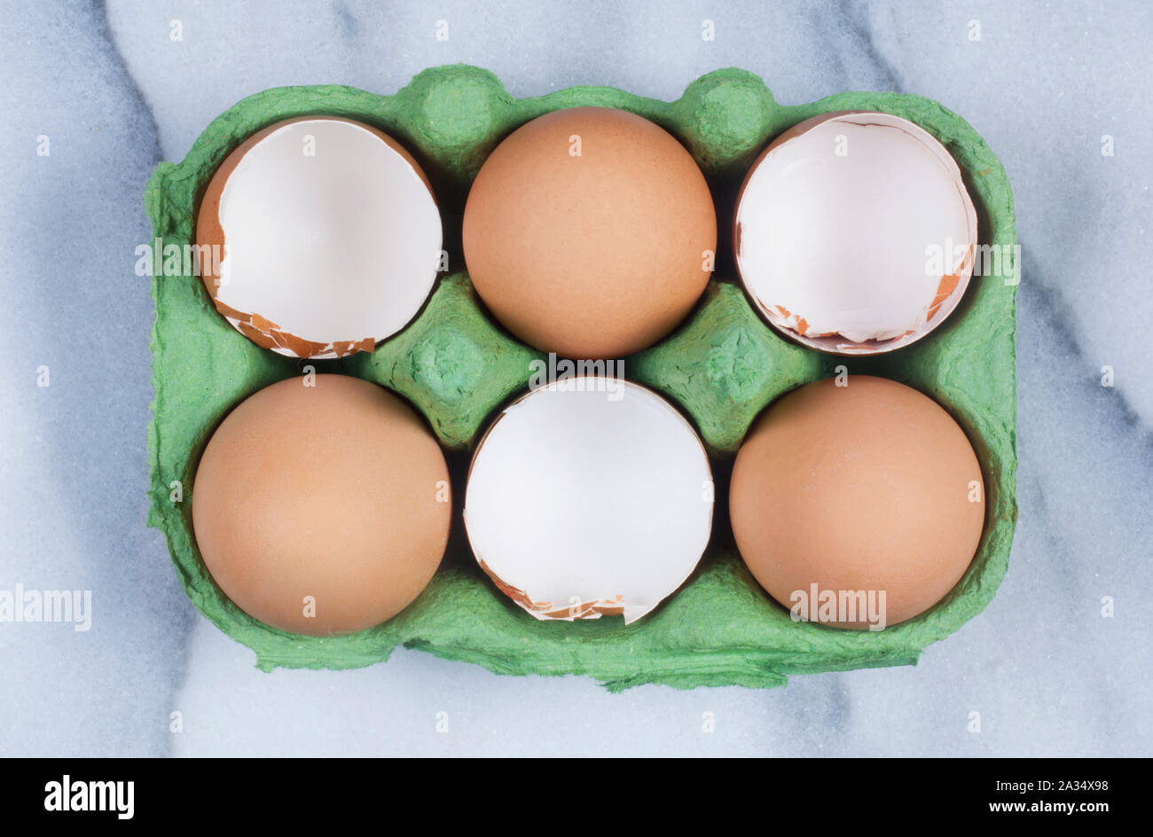 Studio shot of cracked, empty chicken egg shells in an egg box on a ...