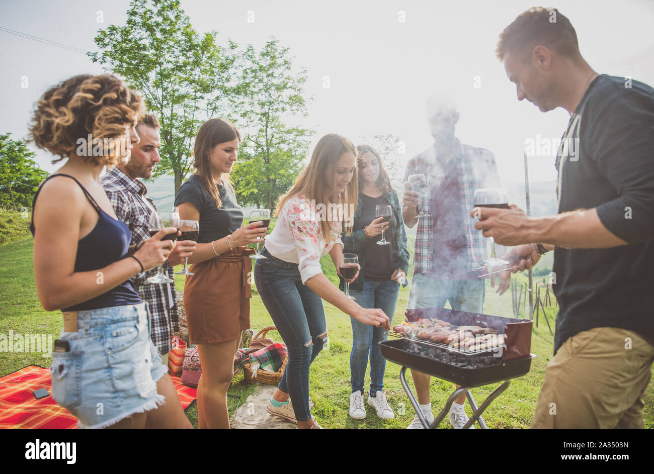 Group of friends spending time making a picnic and a barbeque Stock ...
