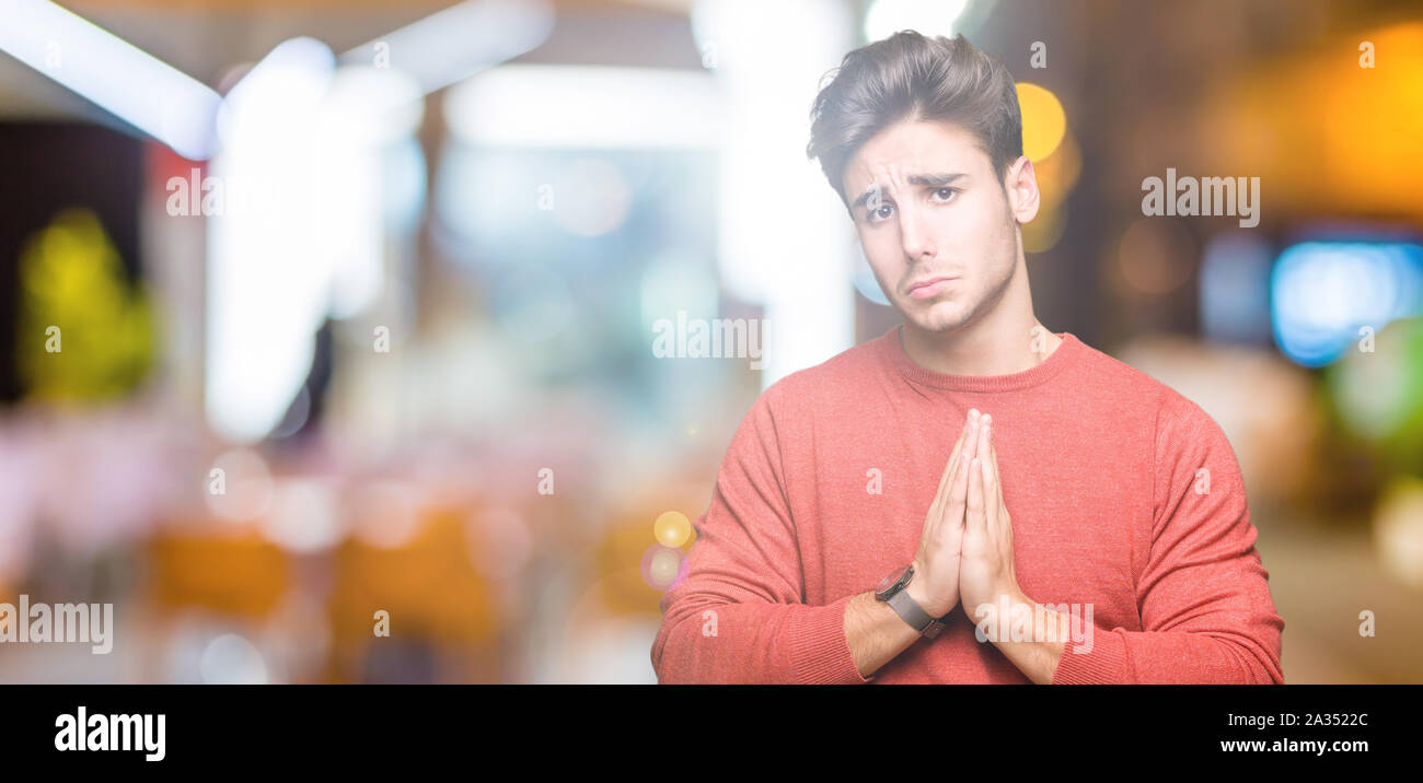 Young handsome man over isolated background begging and praying with ...