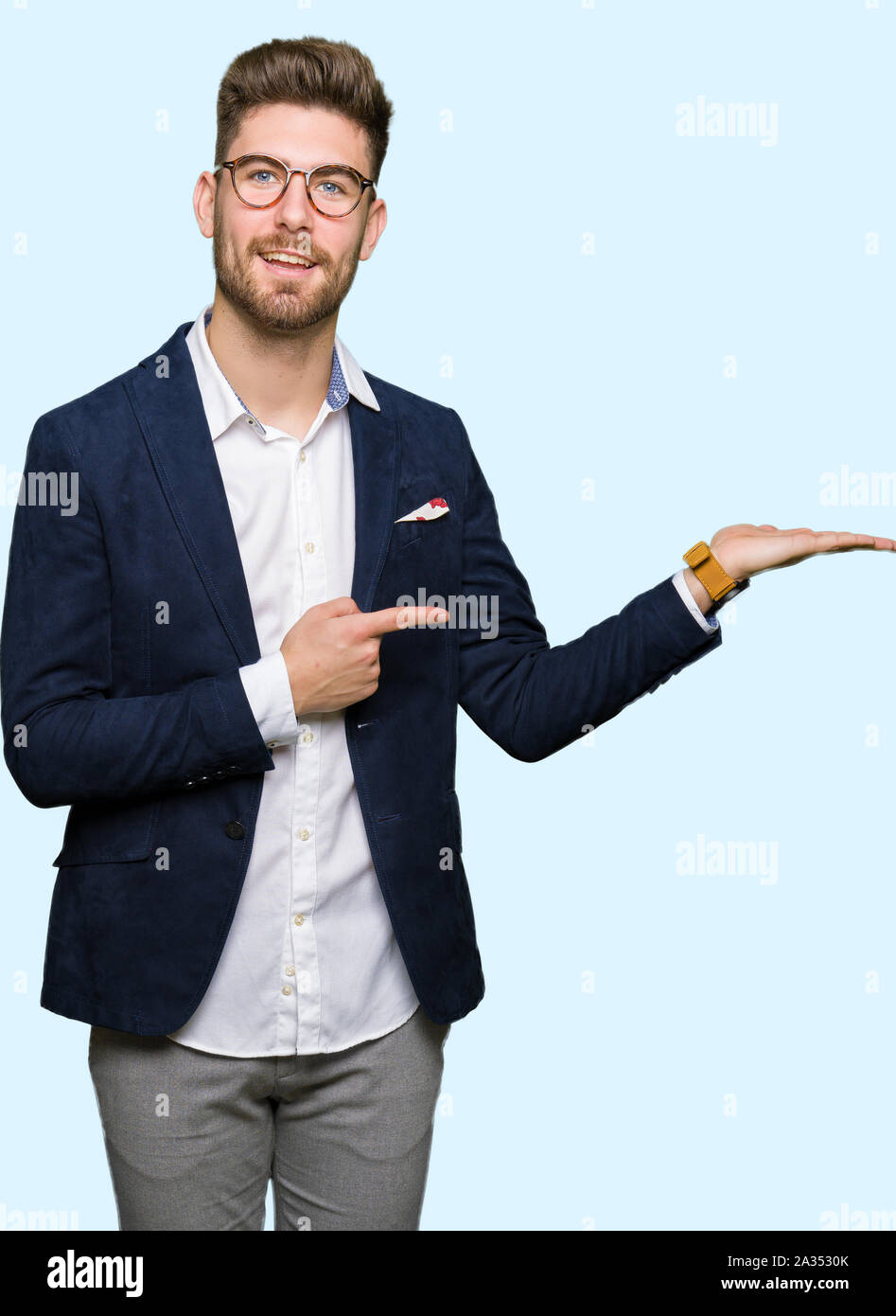 Young handsome business man wearing glasses amazed and smiling to the ...