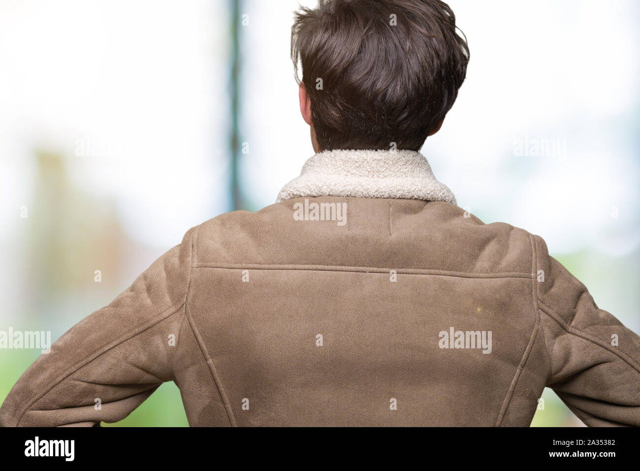 Young handsome man wearing winter coat over isolated background ...