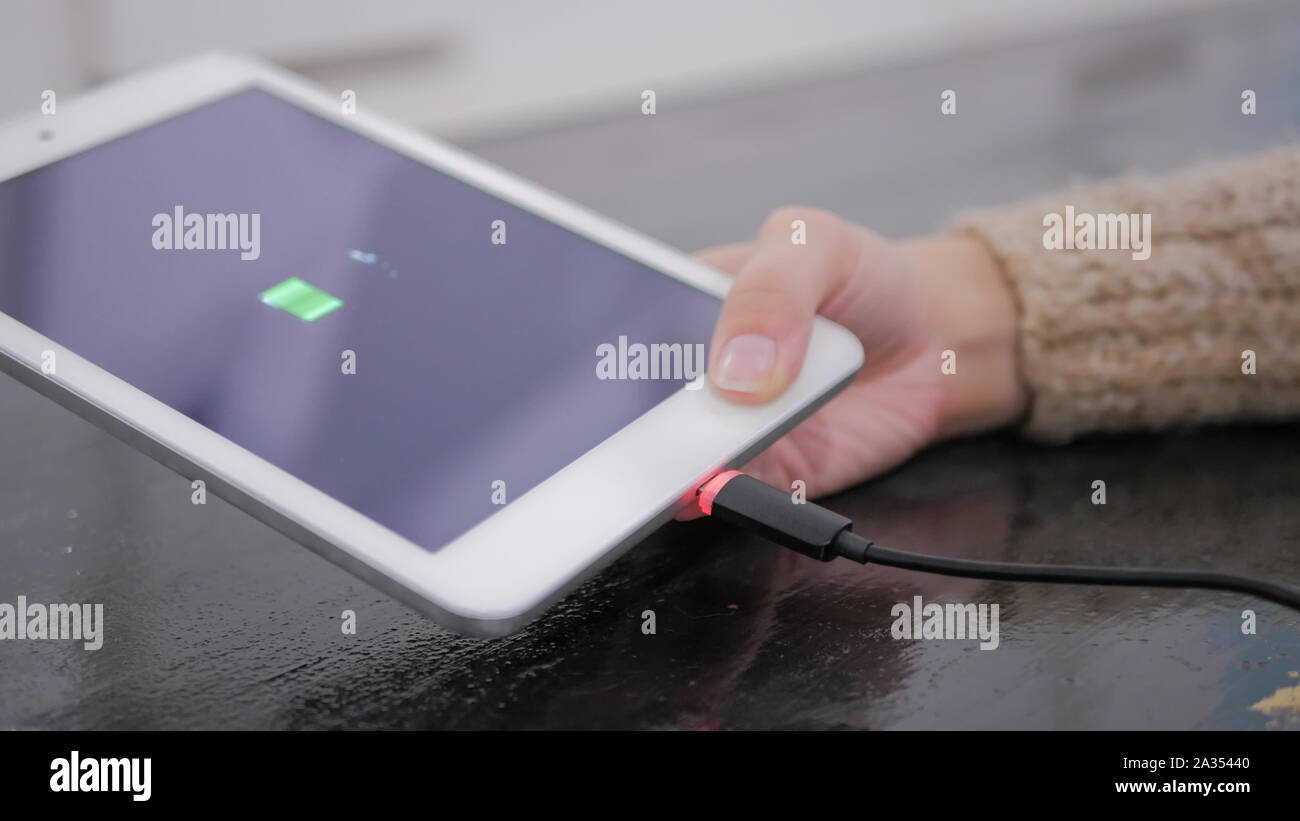 Woman hold pc tablet with low battery icon on screen Stock Photo - Alamy
