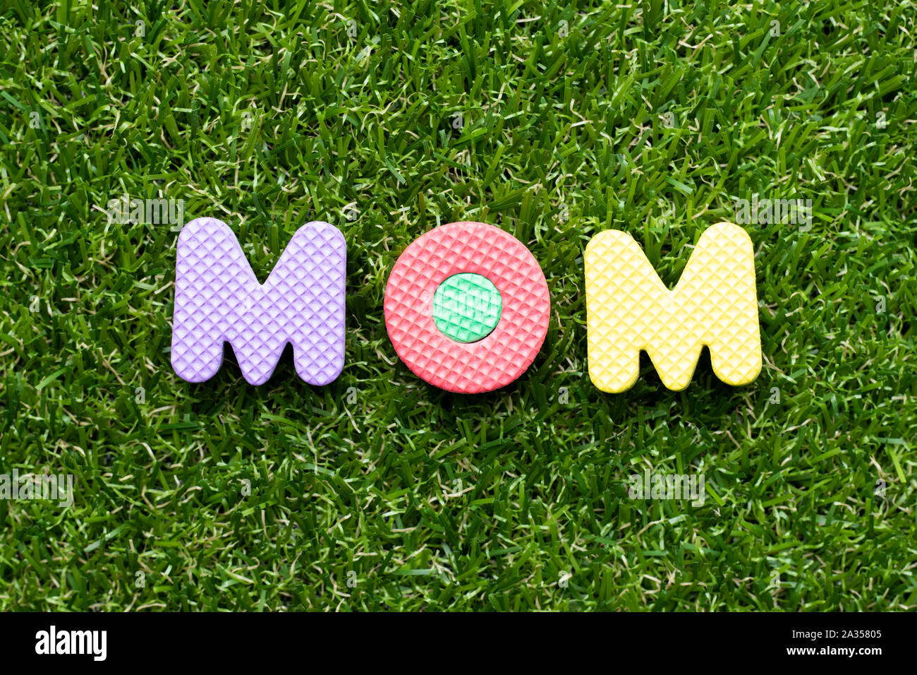 Toy foam letter in word mom on green grass background Stock Photo - Alamy