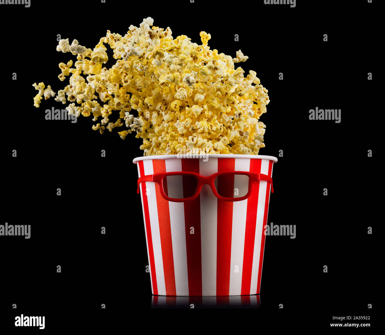Flying popcorn from striped bucket isolated on black background Stock ...