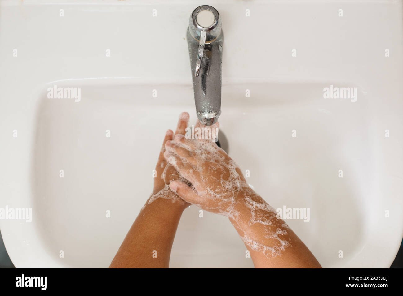 top view of a child washing her hand in washbasin. concept of hand ...