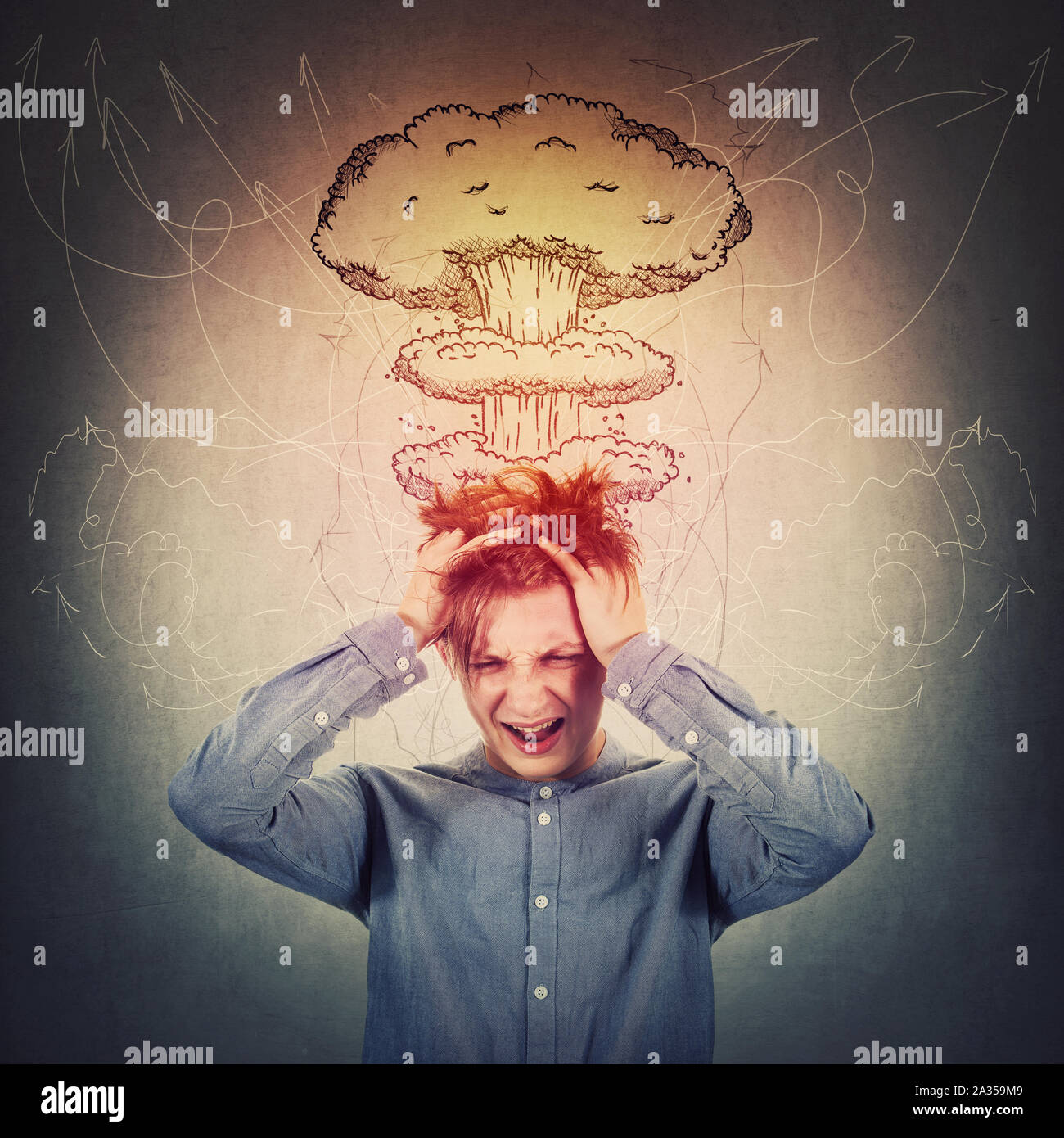 Desperate teenage boy, hands to head, messing up hair and screaming ...