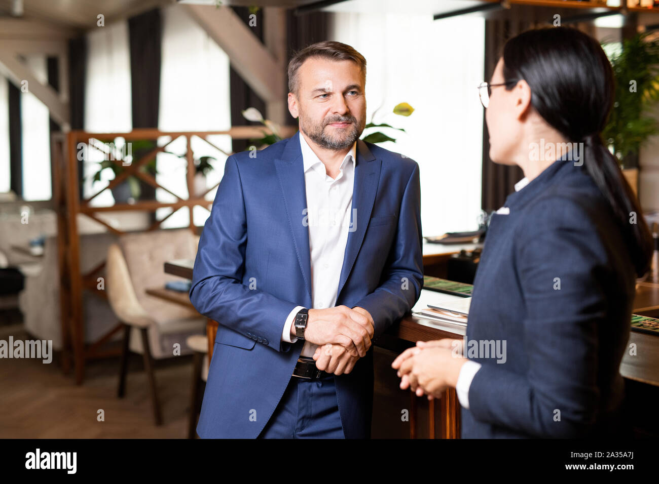 Two contemporary owners of modern restaurant having discussion of ...