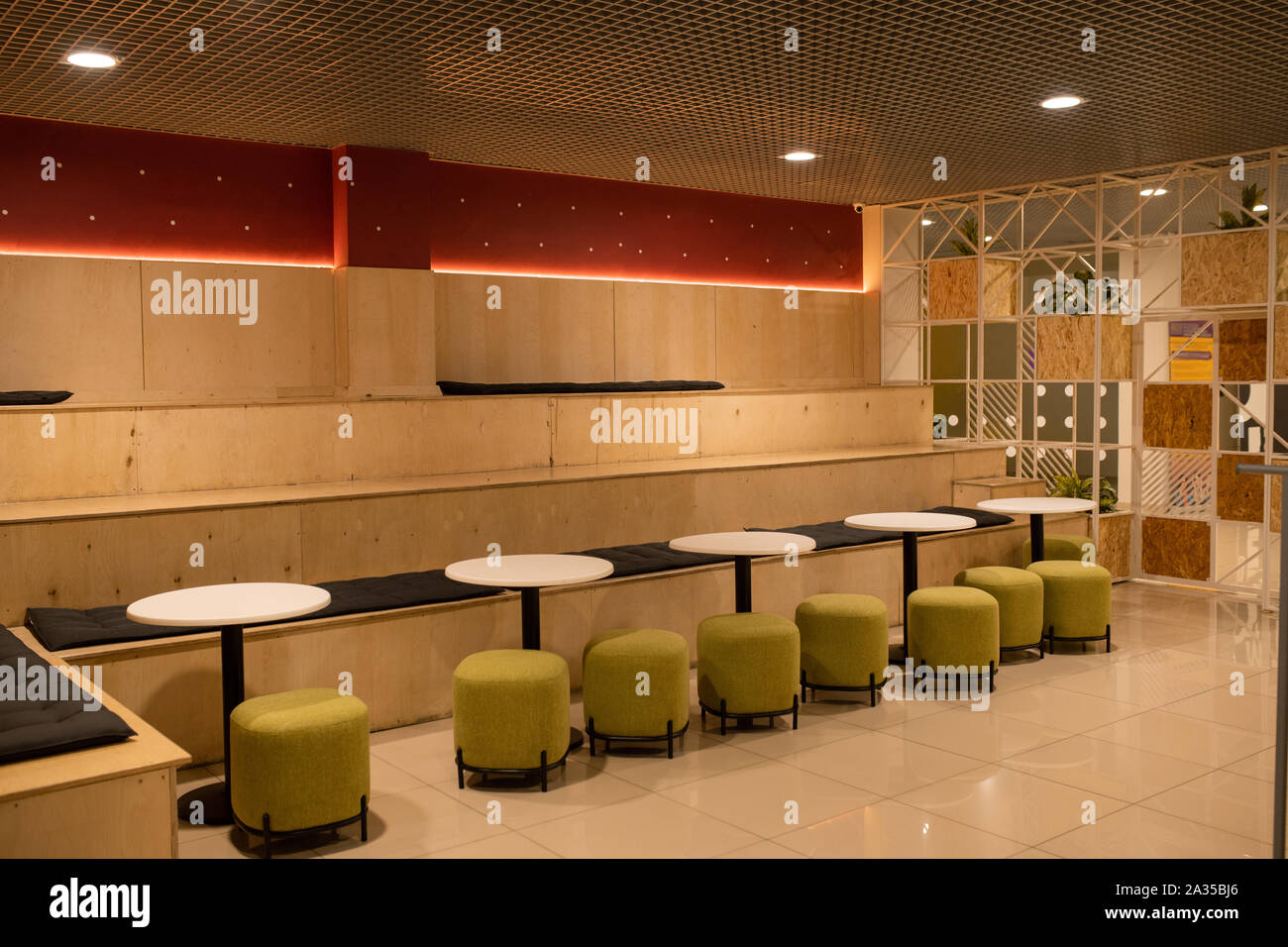 Row of soft velvet chairs by white small round tables inside modern ...