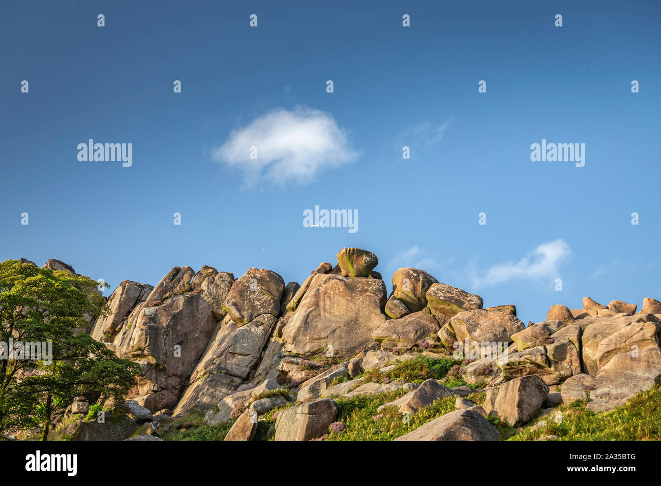 Surreal gritstone rocks formation against blue sky background with low ...