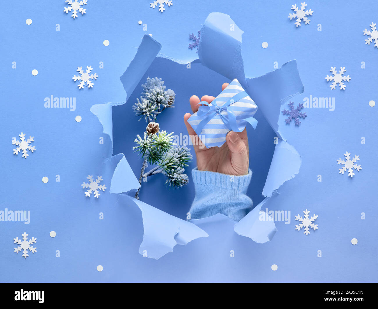 Light purple paper flat lay with snowflakes and ripped hole in the ...