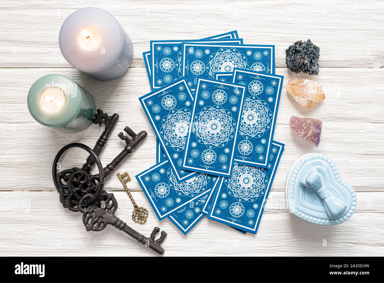 Blue tarot cards and key to the fate on white wooden table background ...