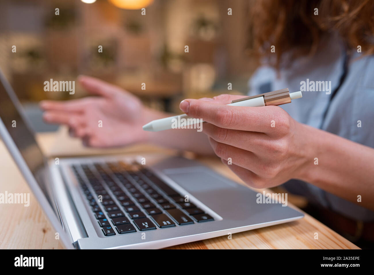 Young female hand with pen over laptop keypad during remote work Stock ...