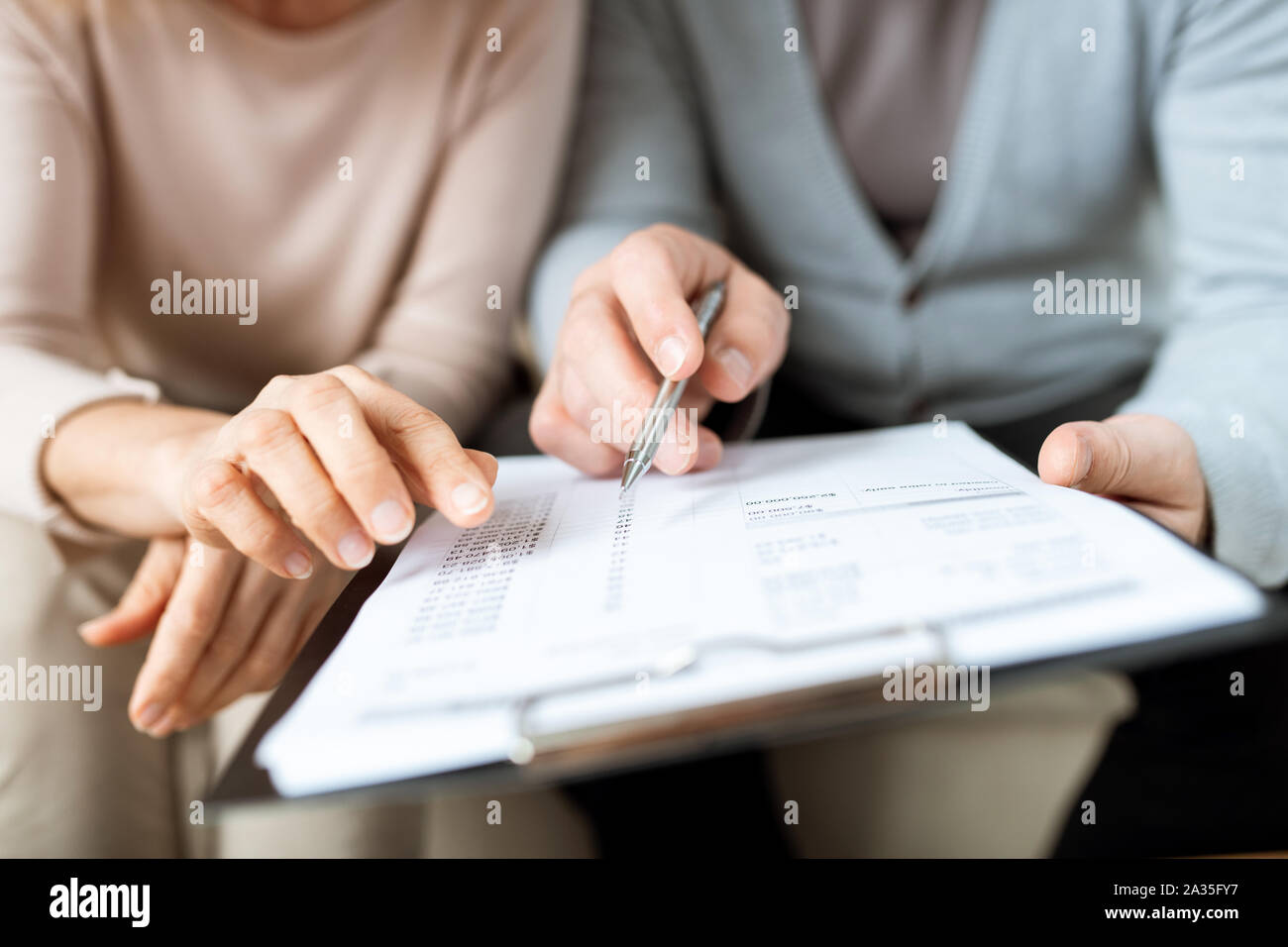 Human hands pointing at one of points of contract or other document ...