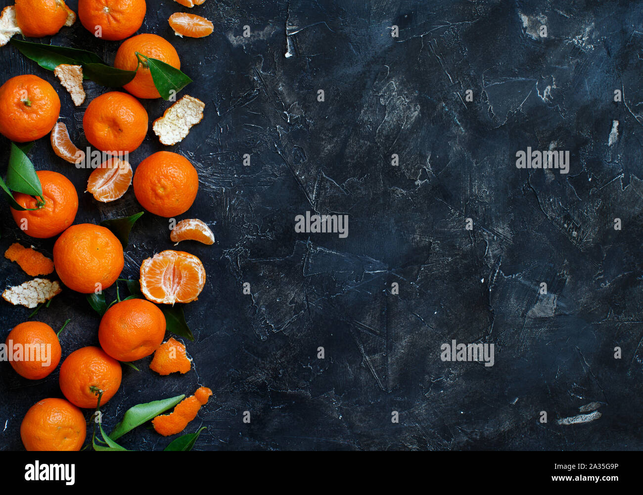 Mandarins with leaves on a dark background Stock Photo - Alamy