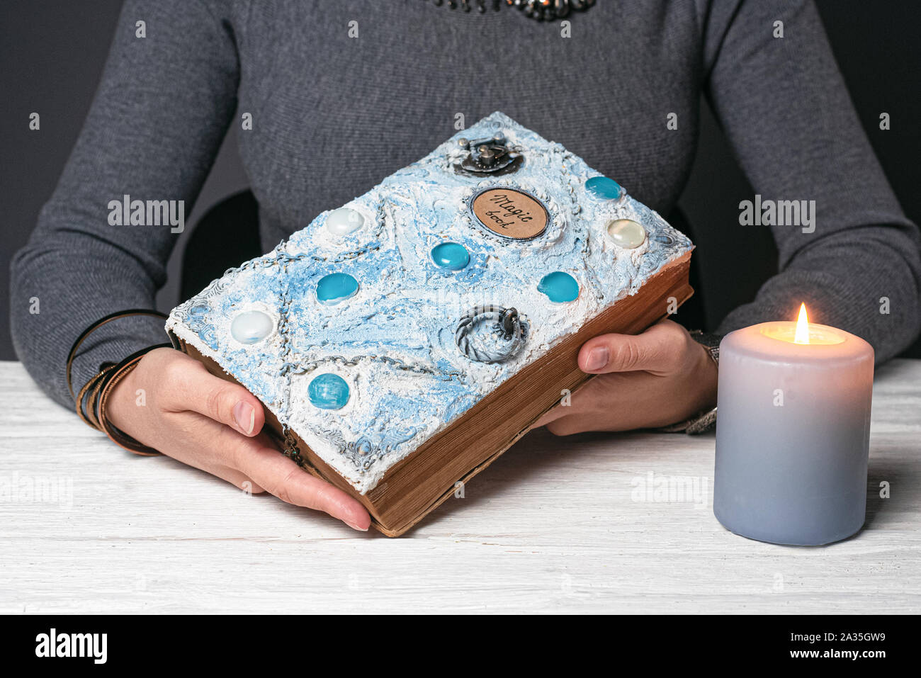 White magic book in a fortune teller hands Stock Photo - Alamy