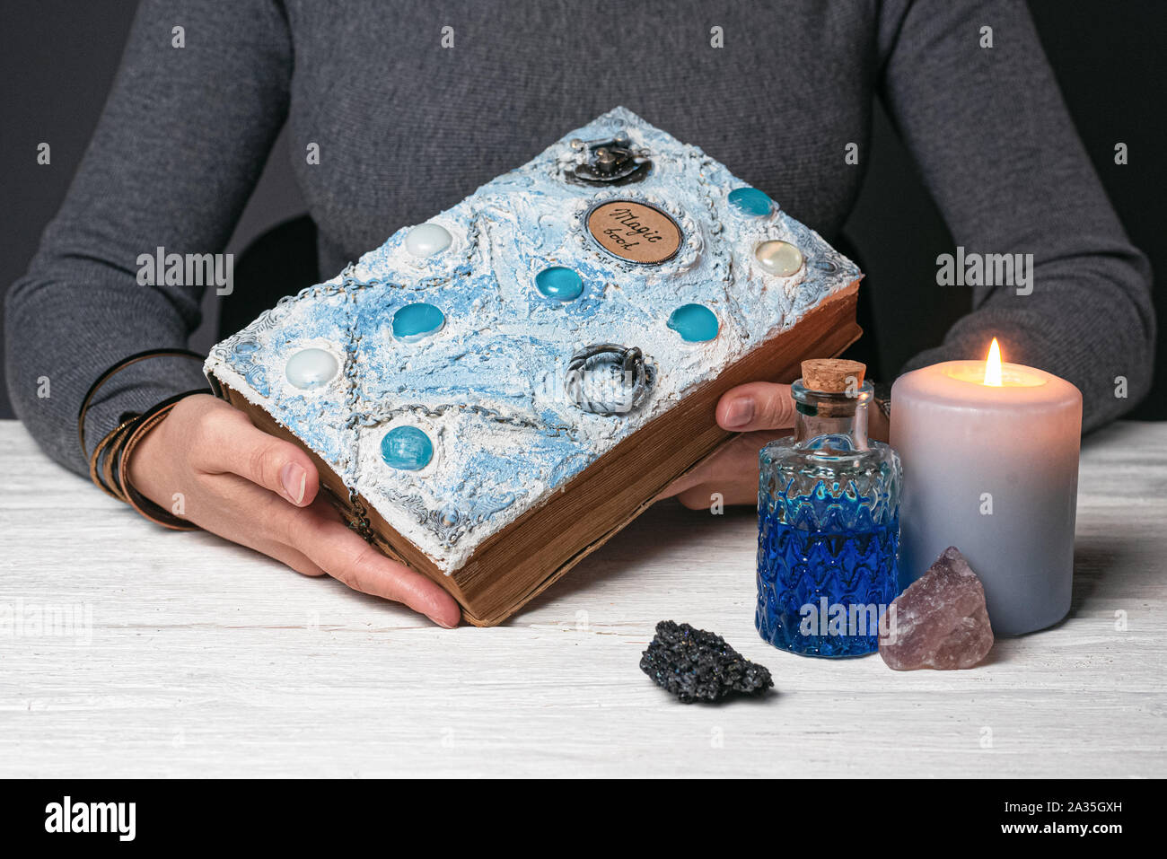 Magic book in a sorcerer hands close up Stock Photo - Alamy