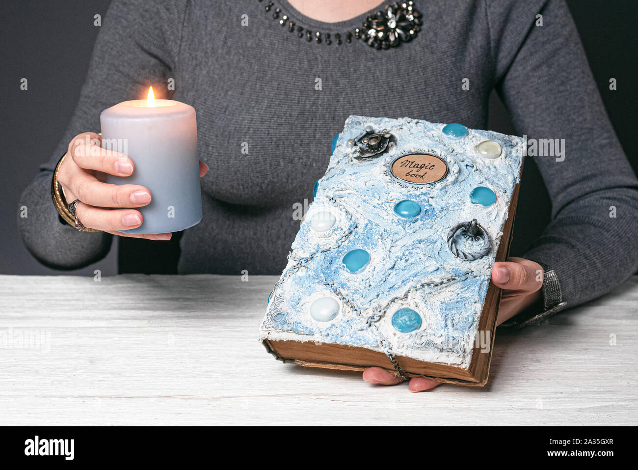White magic book in a sorceress hands Stock Photo - Alamy