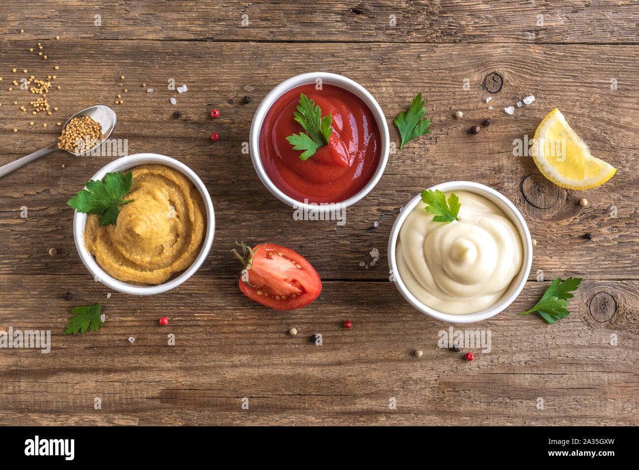 Three classic sauces ketchup, mayonnaise and mustard on wooden ...