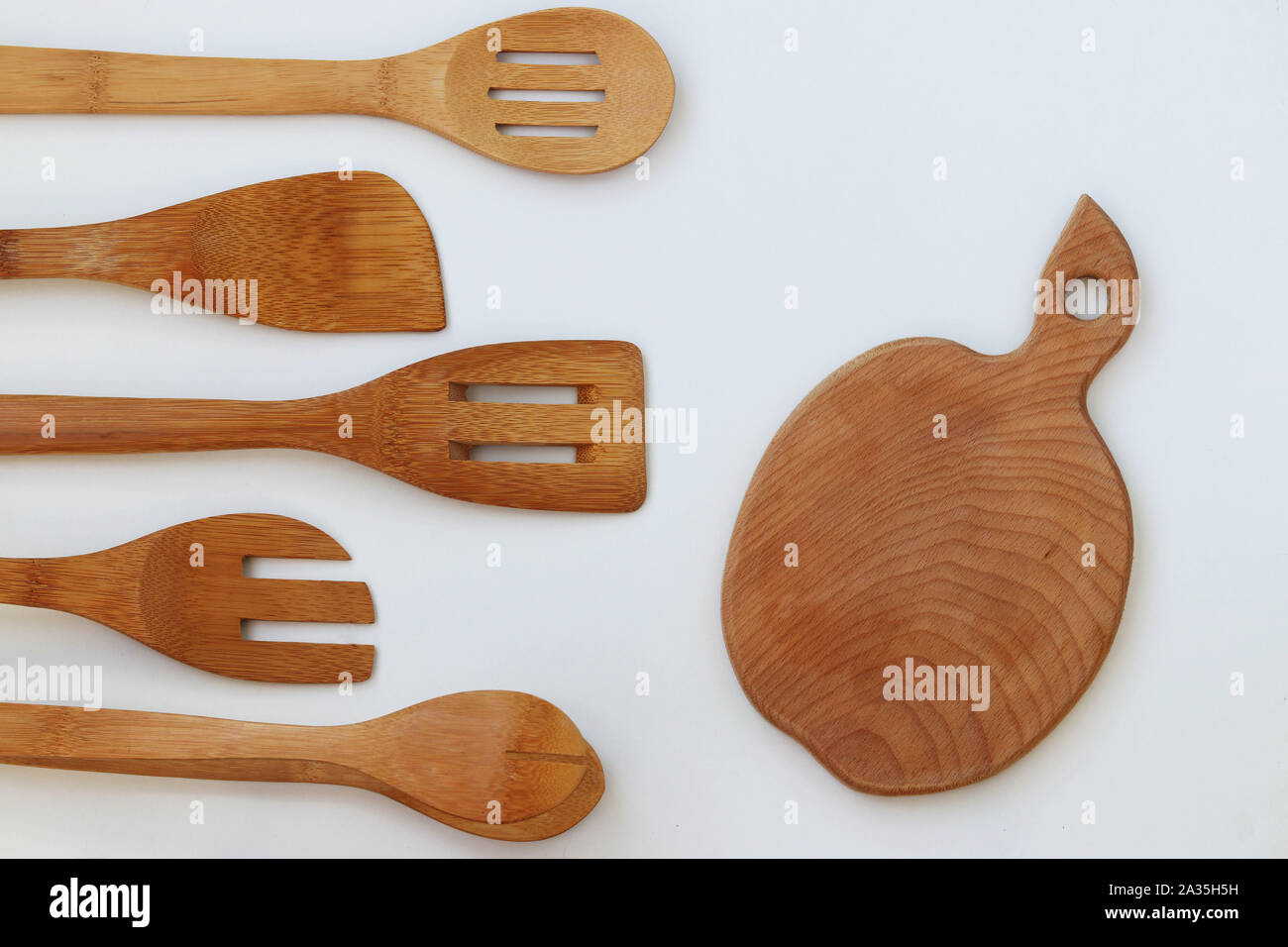 Wooden kitchen utensils on a white background, top view, horizontal ...