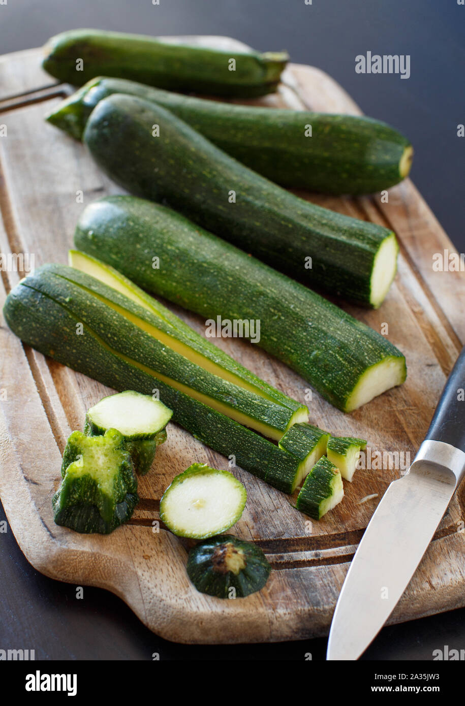Fresh zucchini on a wooden board with a knife Stock Photo - Alamy